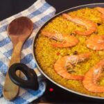 Close-up of seafood paella with prawns and vegetables in a traditional paella pan