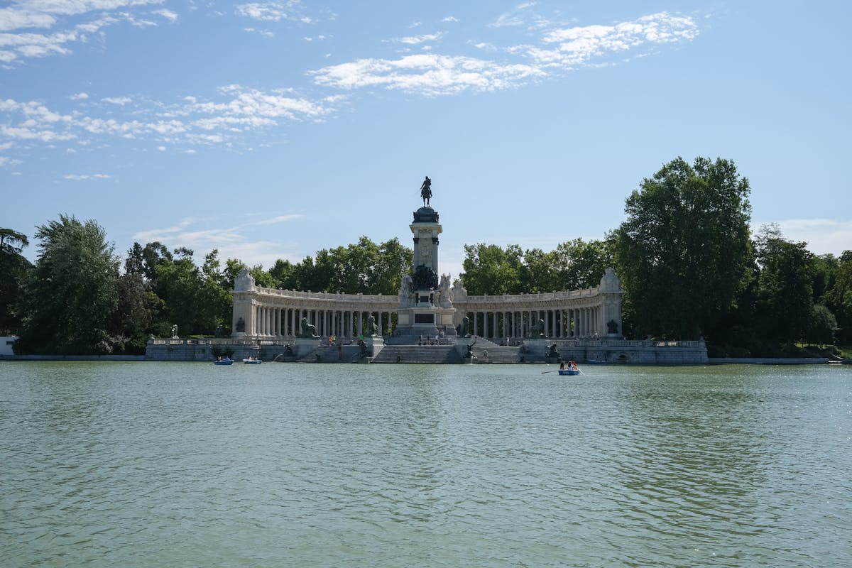 The large ornamental pond at Retiro Park Madrid with row boats and the Alfonso XII monument