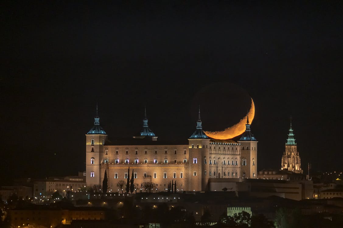 Crescent moon hanging over the Royal Palace of Madrid at night