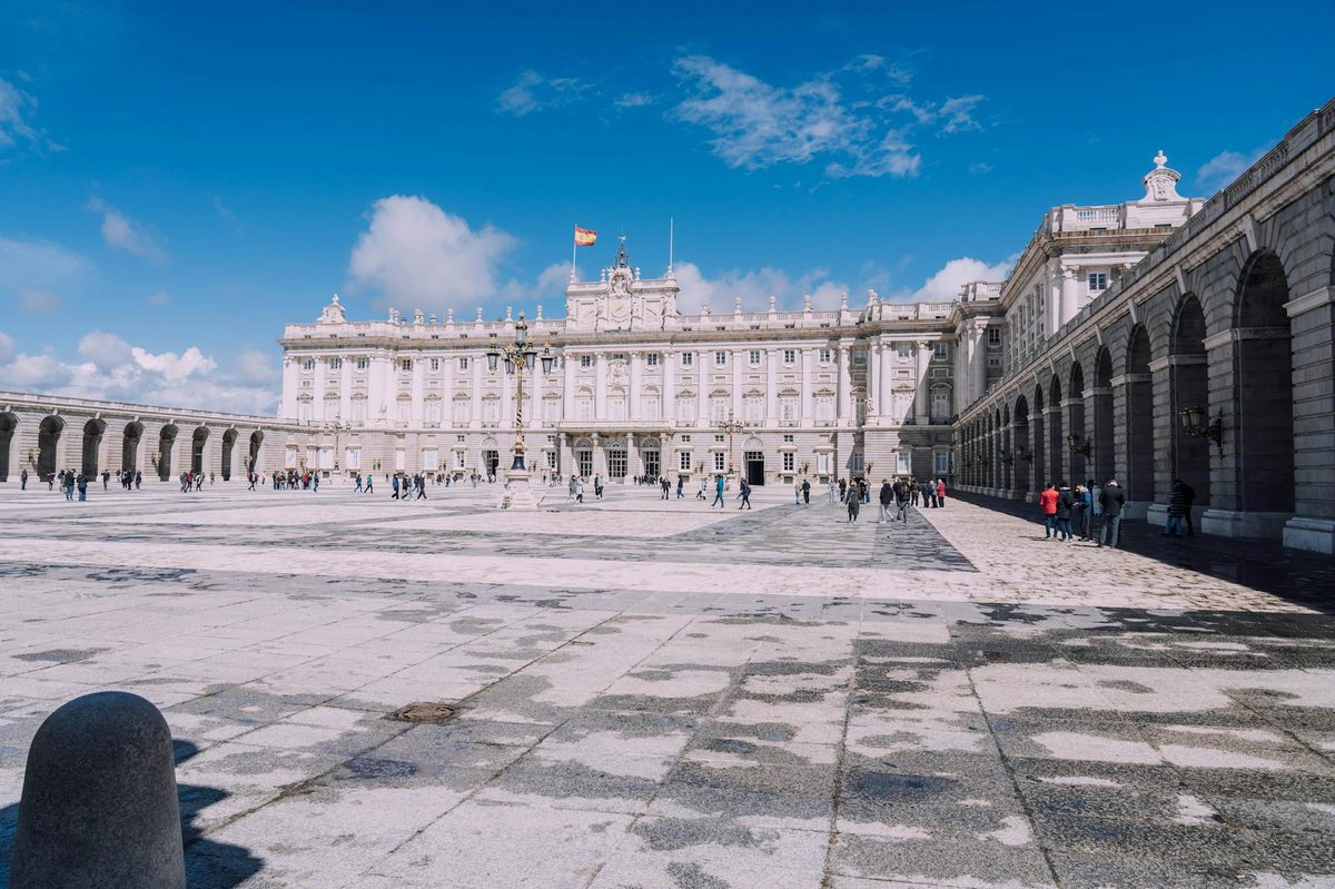 Royal Palace of Madrid under blue sky with plaza