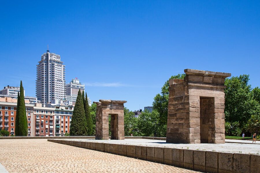 Ancient Temple of Debod in Madrid with modern cityscape in the background