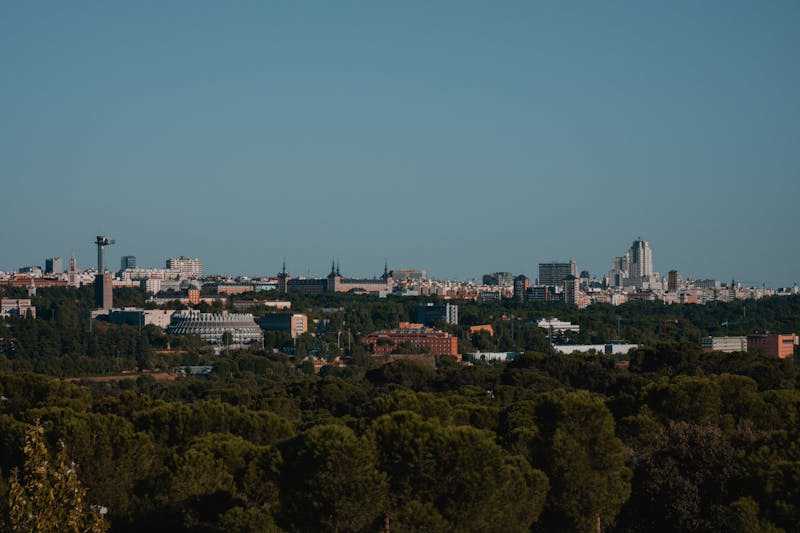 Panoramic view of Madrid city skyline with urban architecture and green areas under clear skies