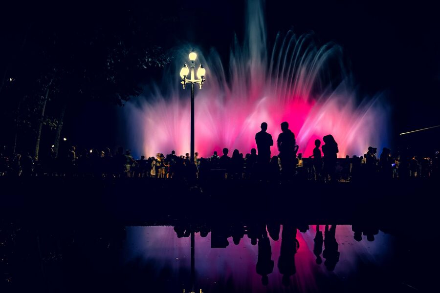 Colorful water display at the Magic Fountain of Montjuic at night with crowd