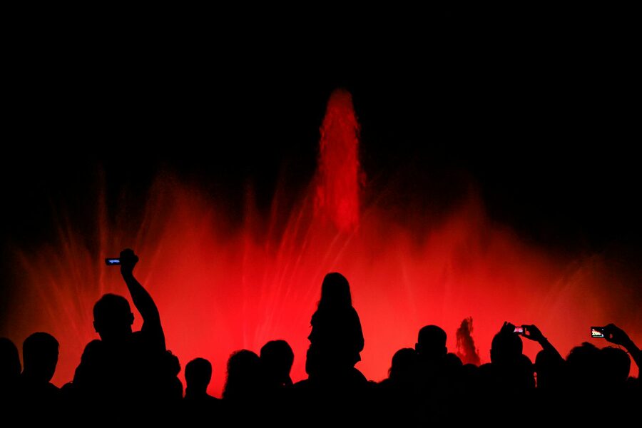 Silhouetted crowd watching colorful Magic Fountain light show in Barcelona