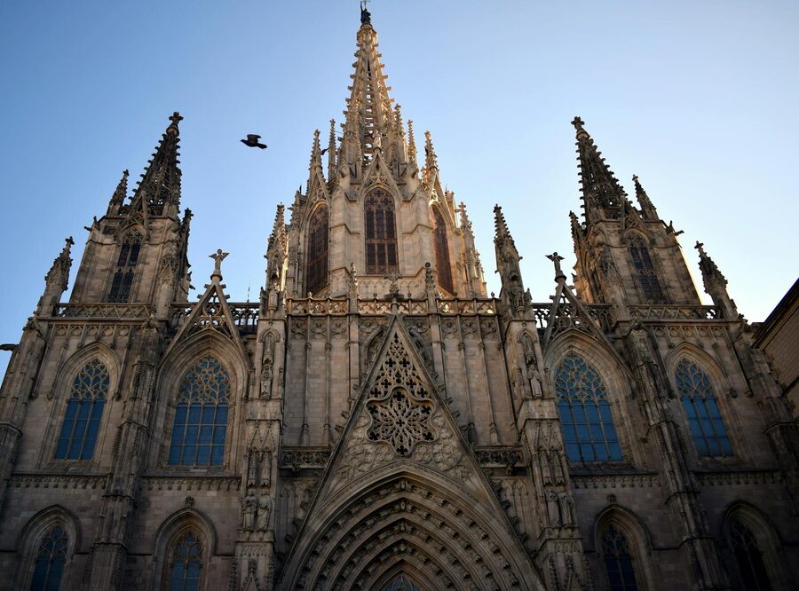 Sagrada Familia lit up at dusk with Barcelona cityscape in the background