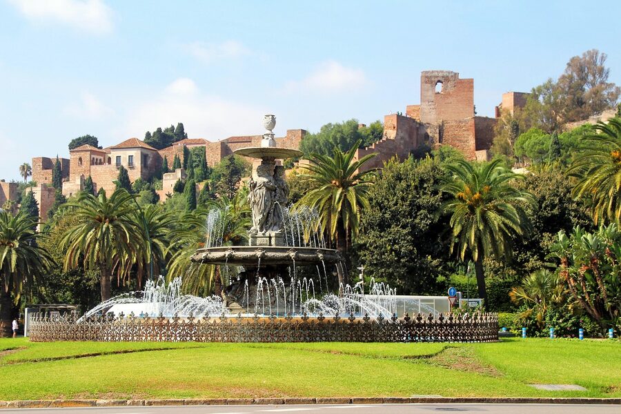 Panoramic view of the Alcazaba and surrounding M&aacute;laga cityscape with a fountain in the foreground
