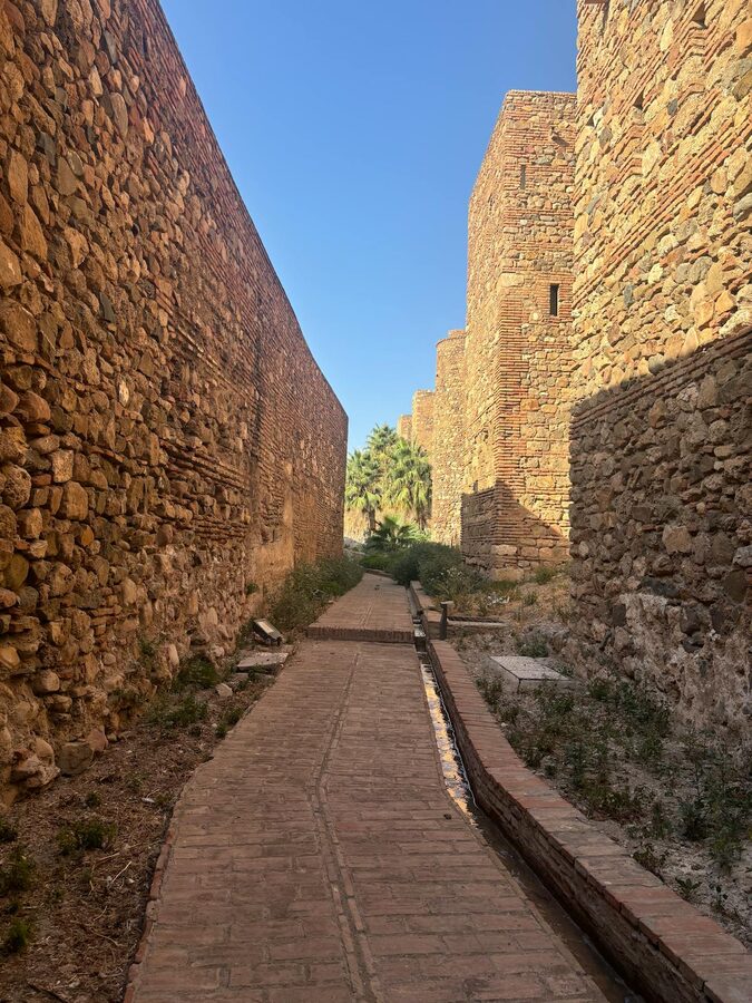 Medieval stone walls and archway inside M&aacute;laga's Alcazaba fortress