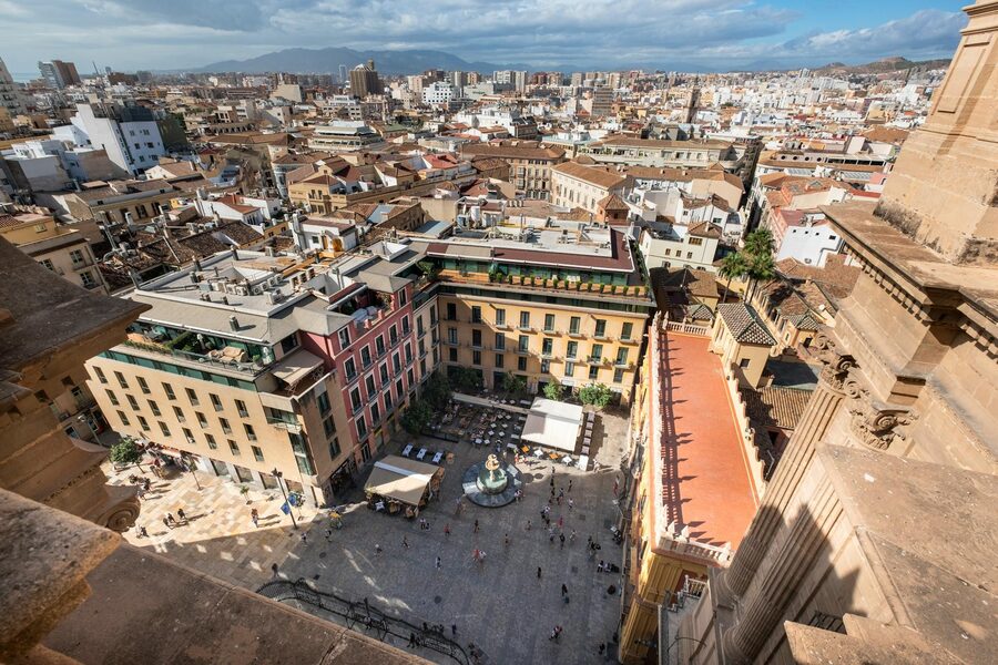 Aerial photograph of a historic plaza in Malaga filled with people and surrounded by buildings