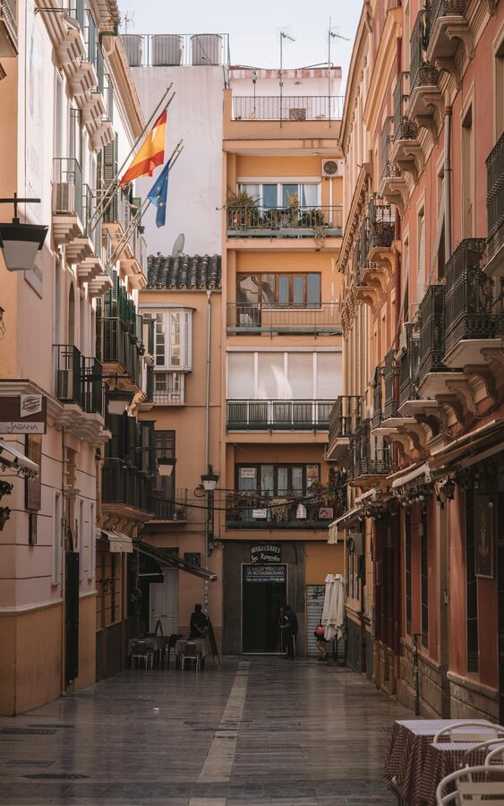Charming narrow M&aacute;laga street lined with balconies and Spanish flags