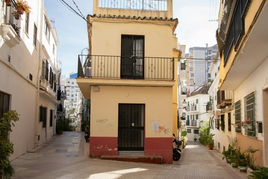 Narrow pedestrian alley with rustic Mediterranean buildings in Malaga old town
