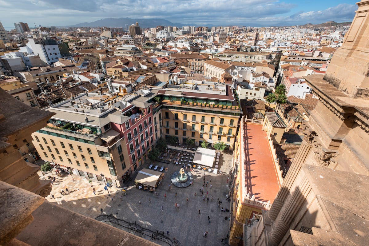 Aerial photograph of a historic plaza in Malaga filled with people and greenery