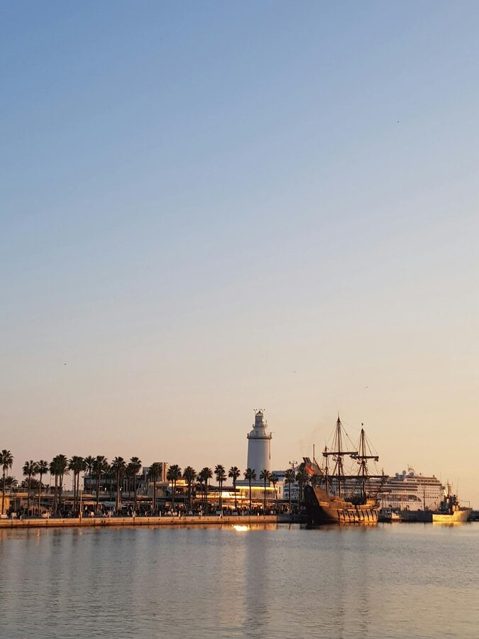 La Farola lighthouse at M&aacute;laga port with boats in the background at sunset