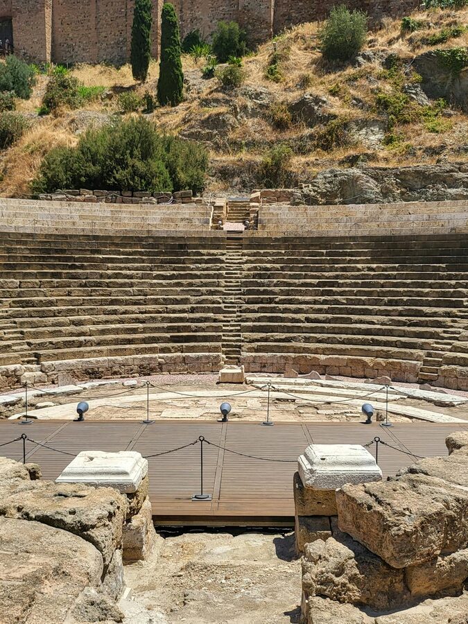 Close-up view of the ancient stone seating and stage area of M&aacute;laga's Roman amphitheatre
