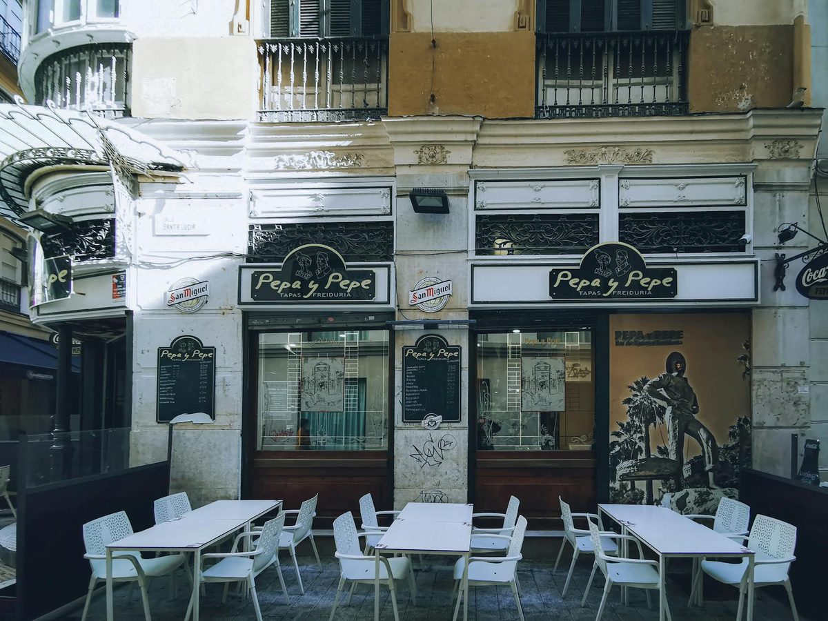 Outdoor seating at a tapas bar in Malaga old town with traditional decor