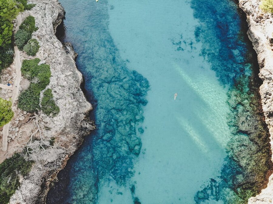 Drone shot of a tranquil cove in Mallorca Spain with clear blue sea and rocky coastline