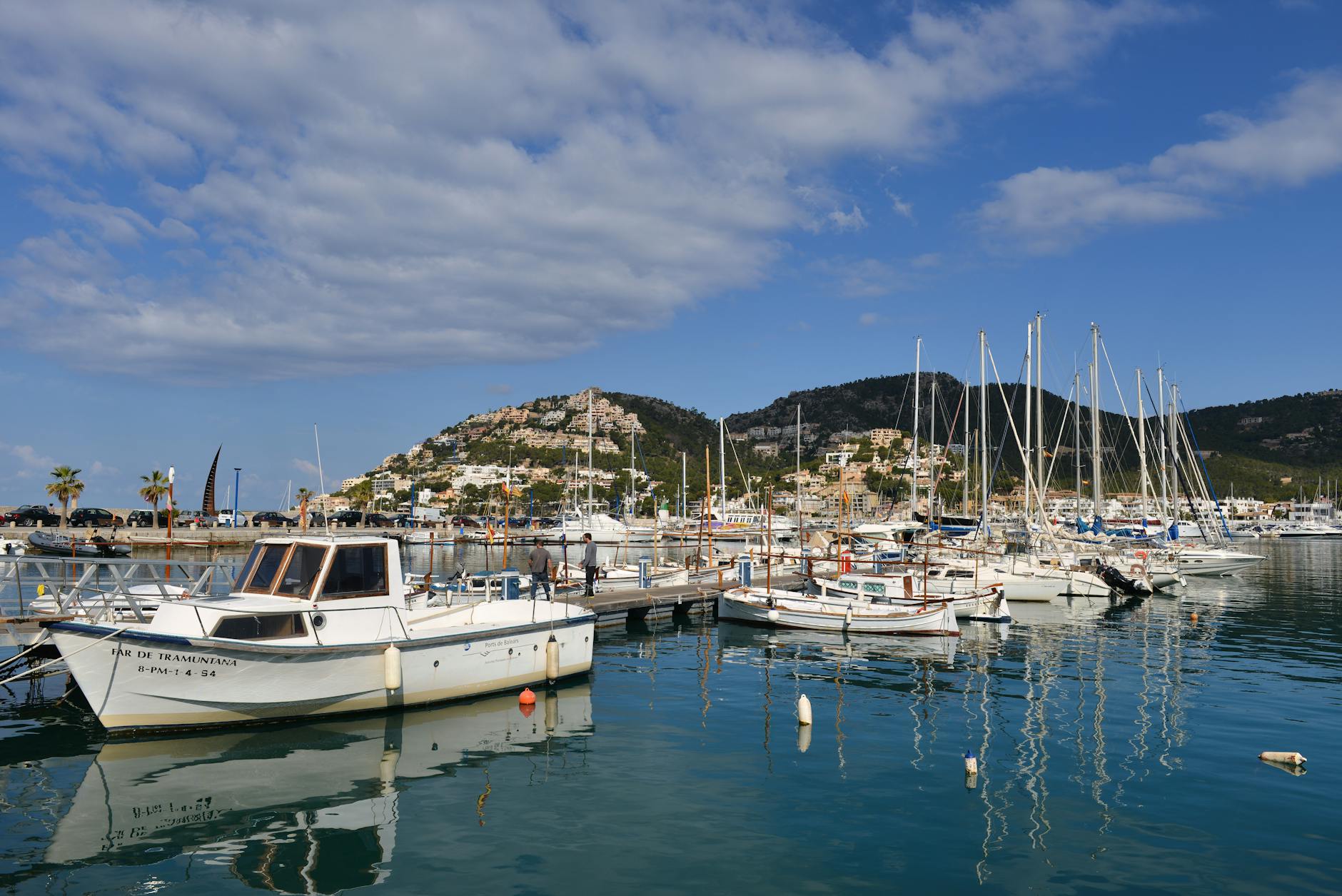 Marina in Mallorca with white boats docked in turquoise waters under blue sky