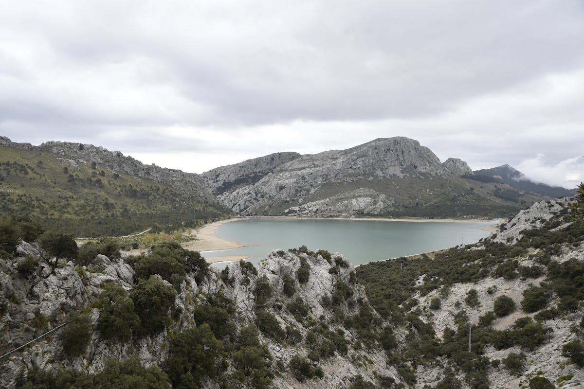 Serene lake surrounded by rocky mountains and greenery in Mallorca Spain