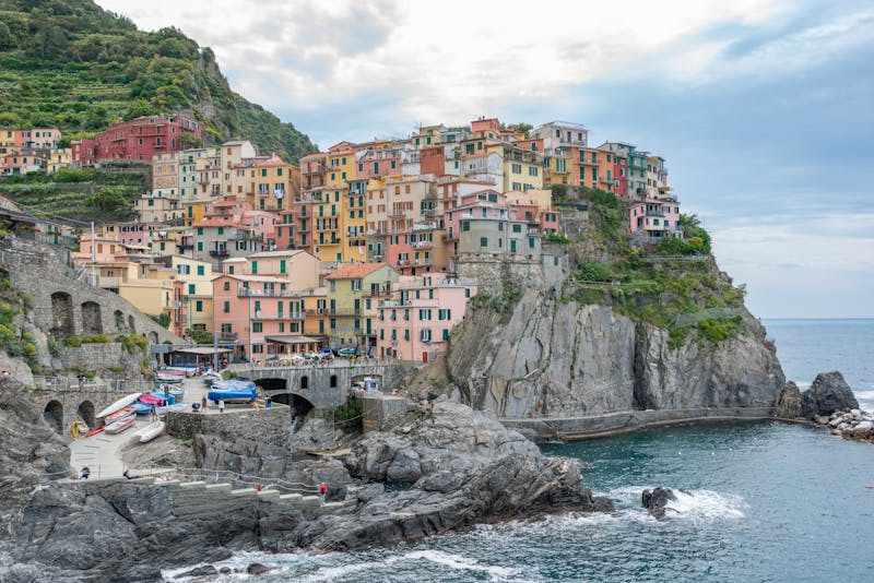 Brightly colored houses of Manarola stacked on the steep Ligurian cliffside above the Mediterranean Sea
