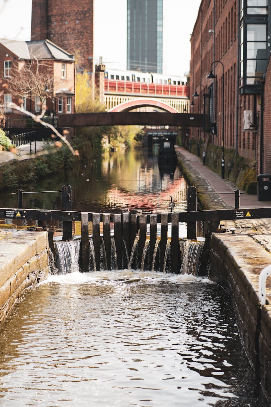 Historic canal bridges reflecting in still water in Castlefield Manchester