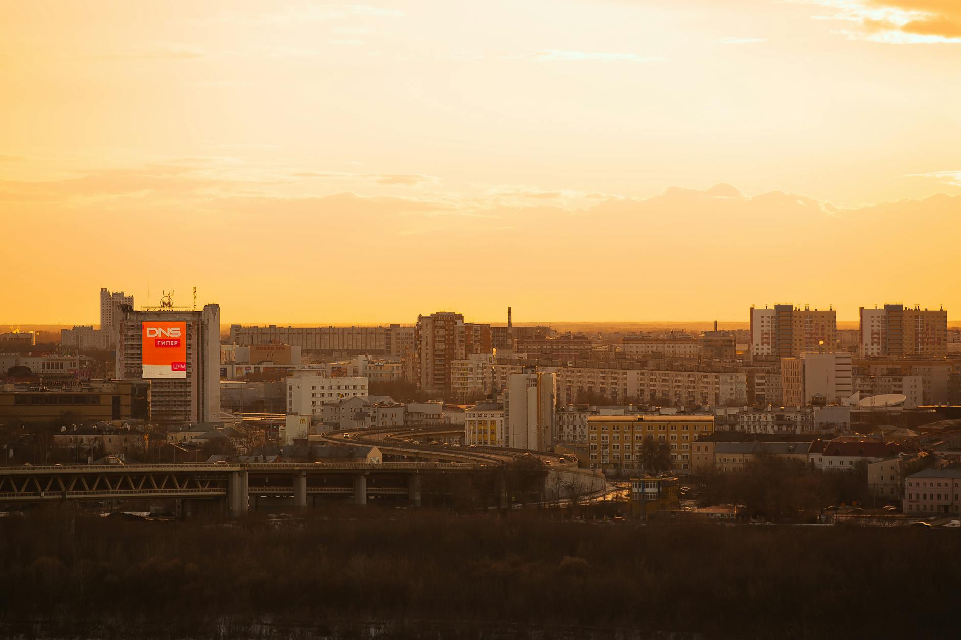 Manchester city skyline glowing at sunset with warm orange and purple tones