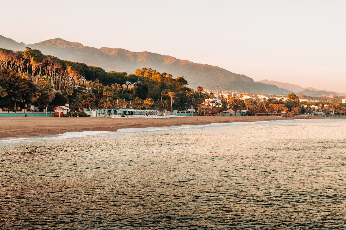 Peaceful sunrise at Marbella beach with mountains in background