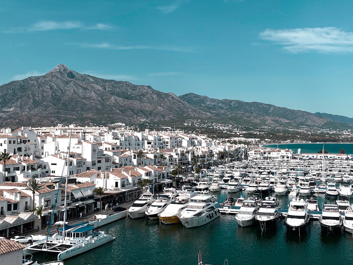 Aerial view of Marbella marina with yachts and mountain backdrop