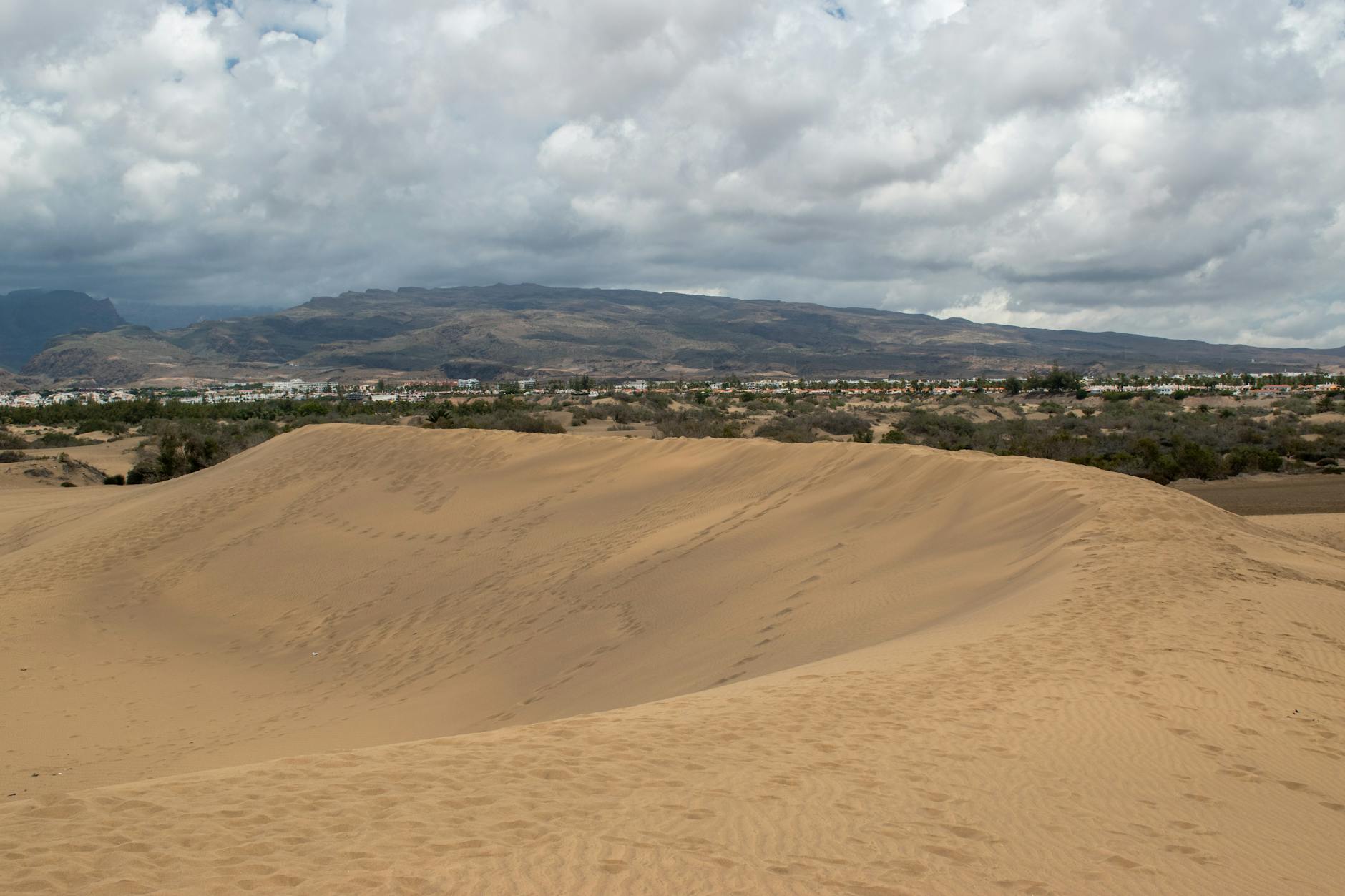 Maspalomas sand dunes with mountainous backdrop in Gran Canaria