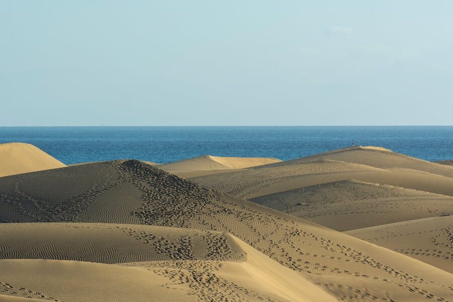 Golden sand dunes of Maspalomas with blue sea in the background