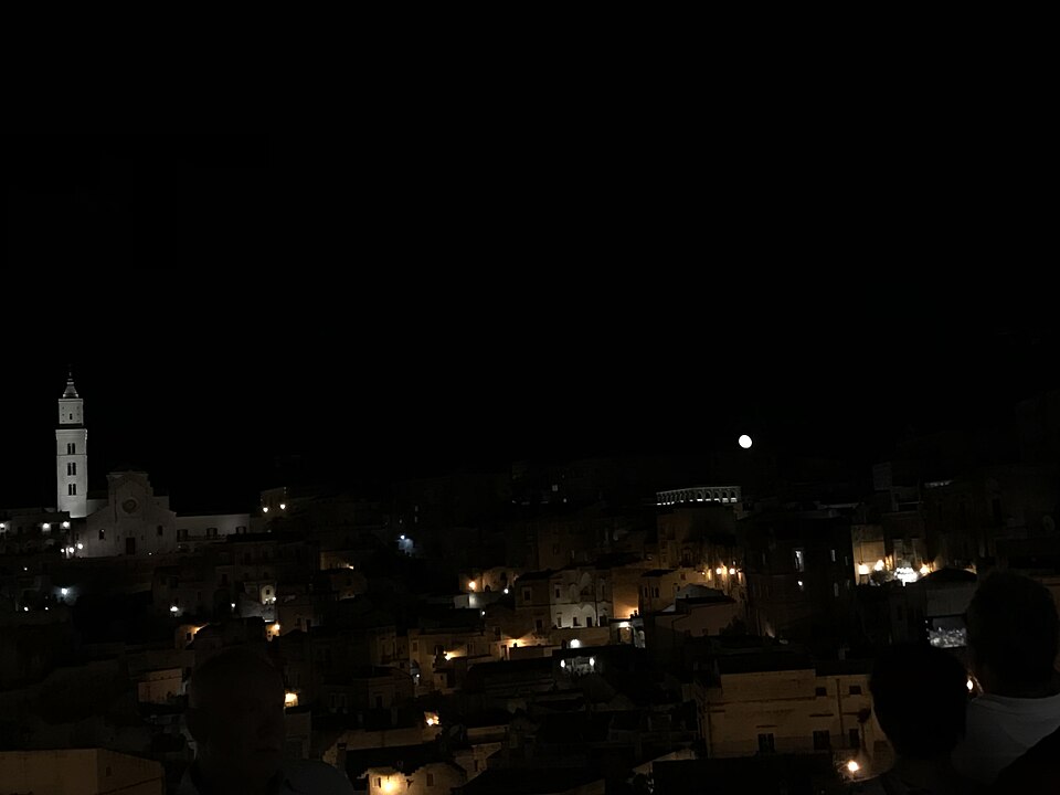 The Sassi di Matera cave dwellings lit up at night with warm golden lights