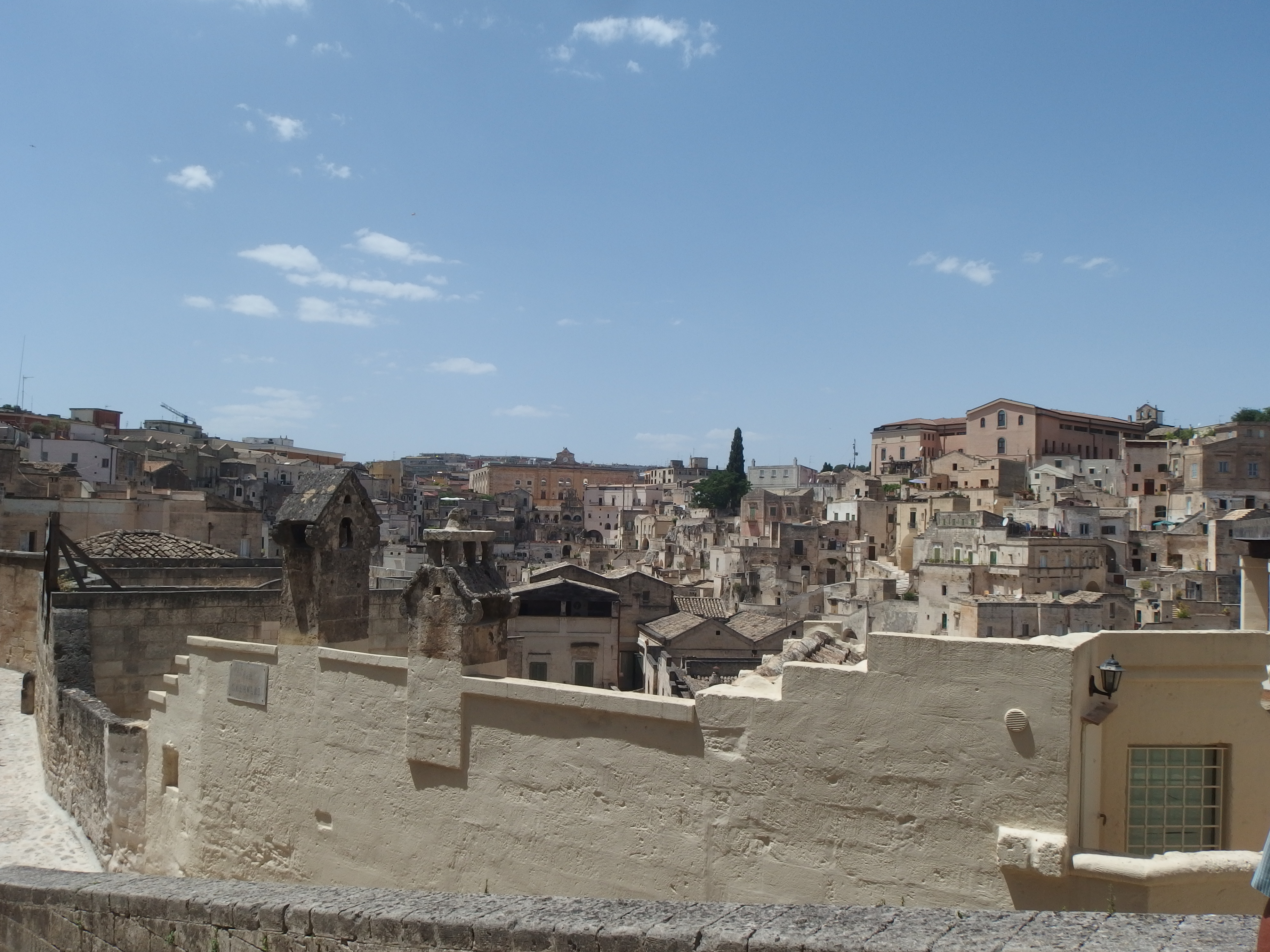 Narrow stone street winding through the Sassi di Matera with cave dwellings on both sides
