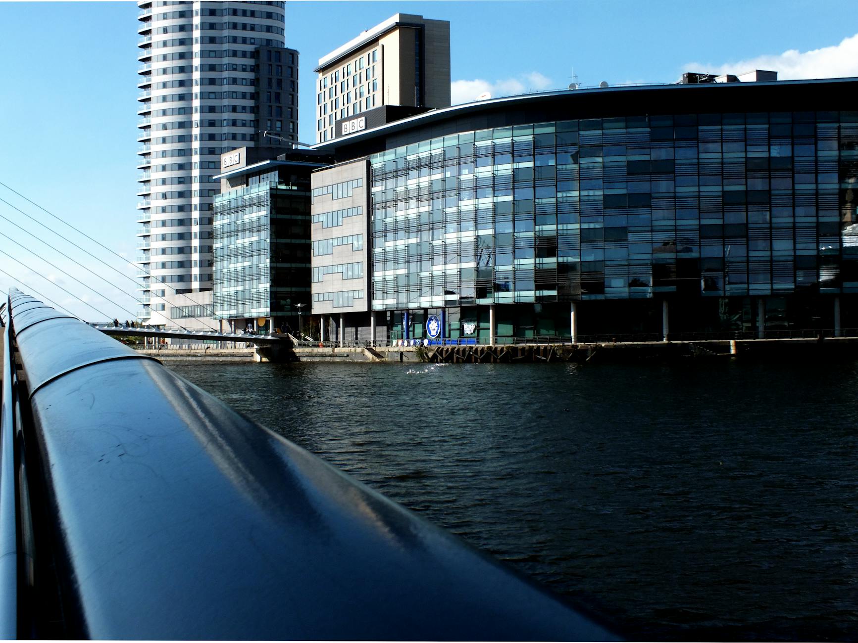 Glass-fronted MediaCityUK buildings with their reflections in the quays water