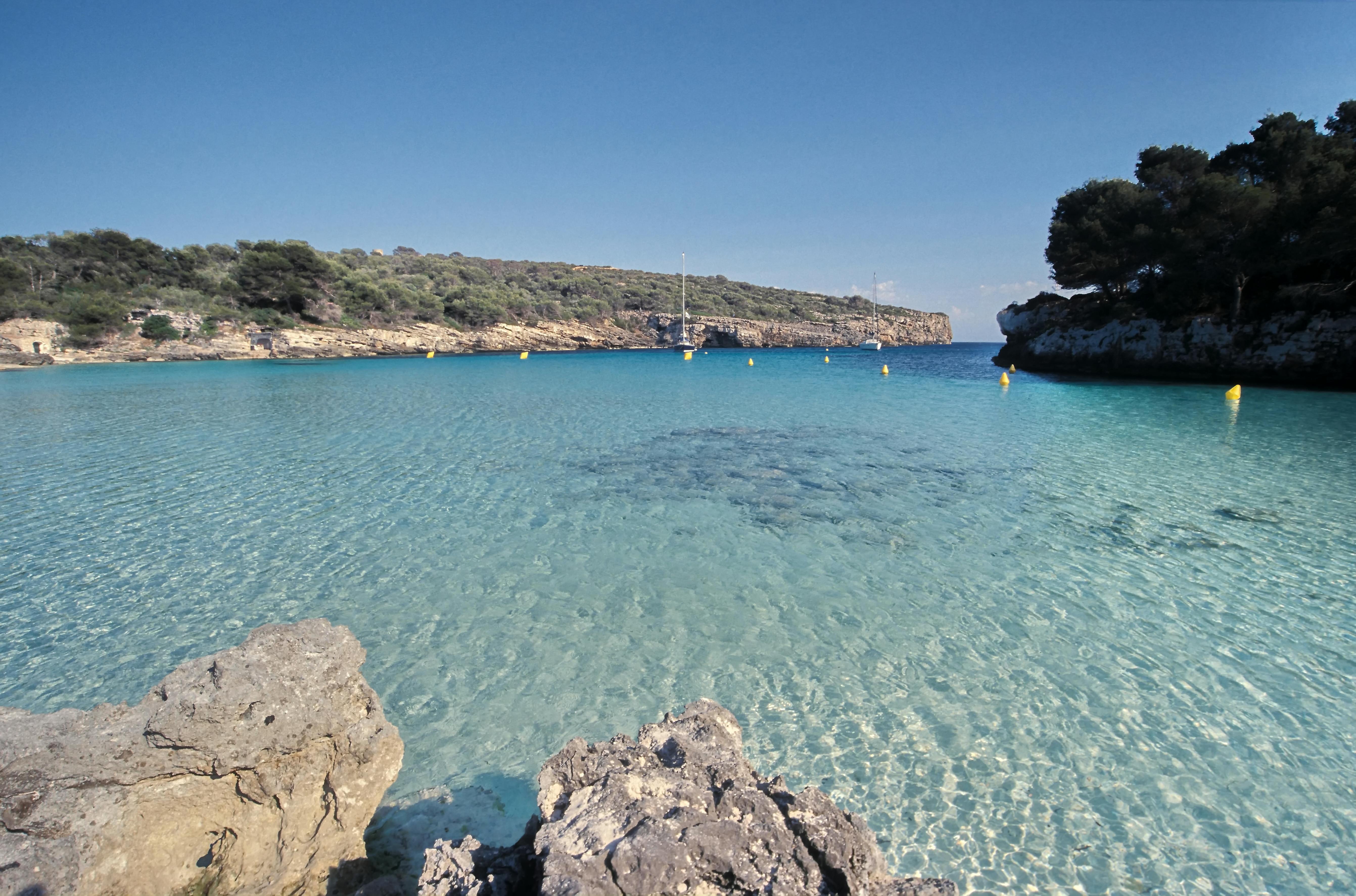 Crystal clear turquoise waters of a hidden cove along the Menorca coastline