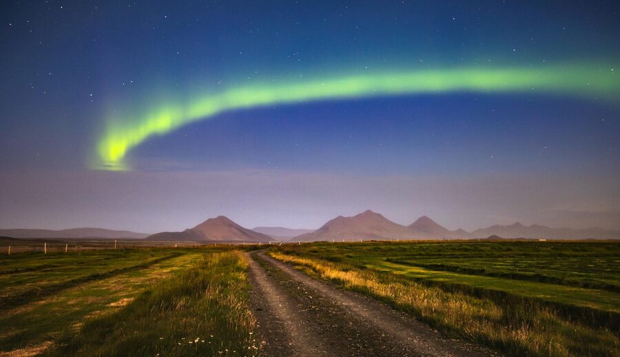 Spellbinding view of the aurora borealis illuminating the Icelandic night sky over a rural landscape.