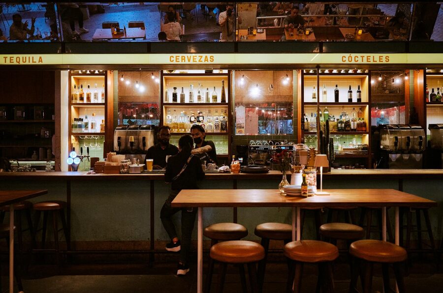 Bar interior at night with patrons enjoying drinks