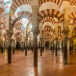 The iconic red and white striped arches inside the Mosque-Cathedral of Cordoba stretching into the distance