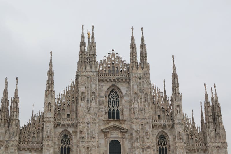 Close-up view of Milan Cathedral Gothic facade with intricate marble carvings and spires