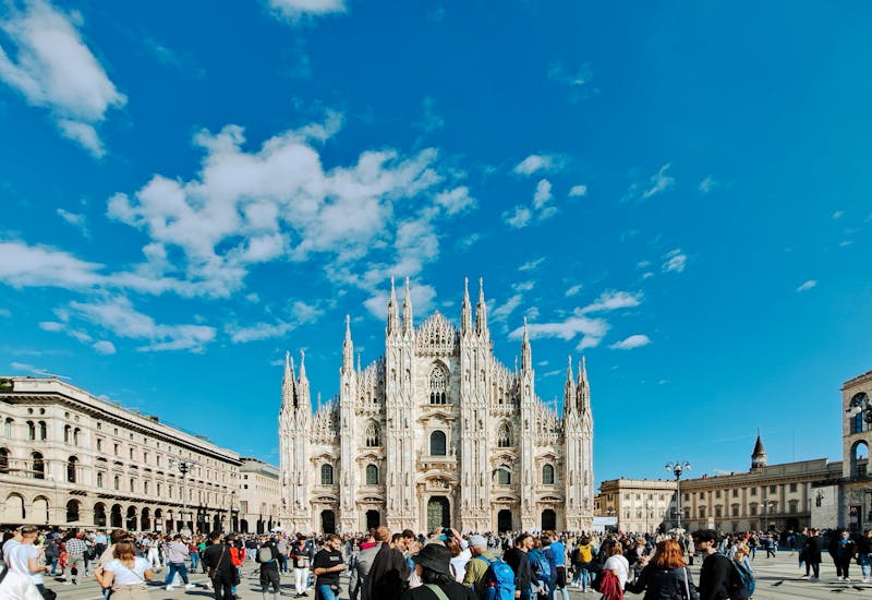 Panoramic view of Milan Cathedral with bustling crowd on a sunny day