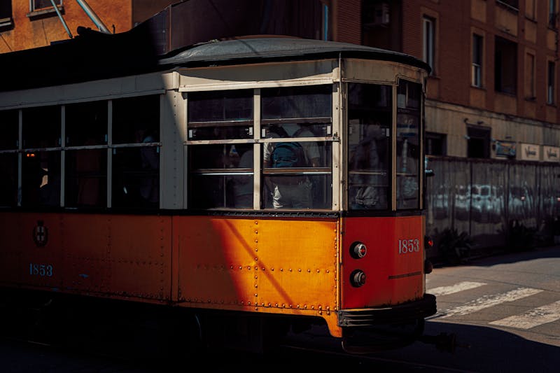 Vintage orange tram on a sunny street in Milan Italy