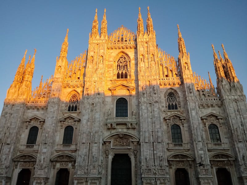 The Milan Duomo cathedral glowing in warm sunset light