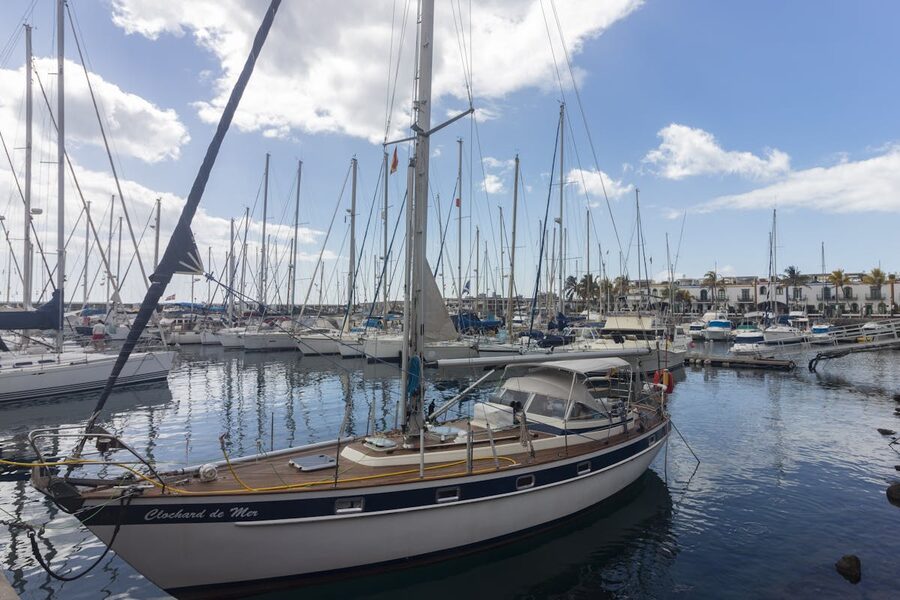 Yachts moored in the scenic Mogan harbor with mountains behind