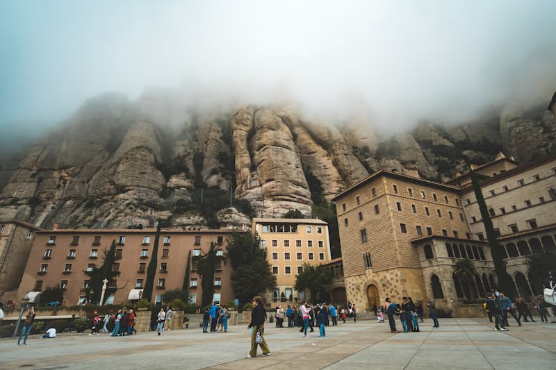 Montserrat Monastery building with fog rolling over the mountains behind it