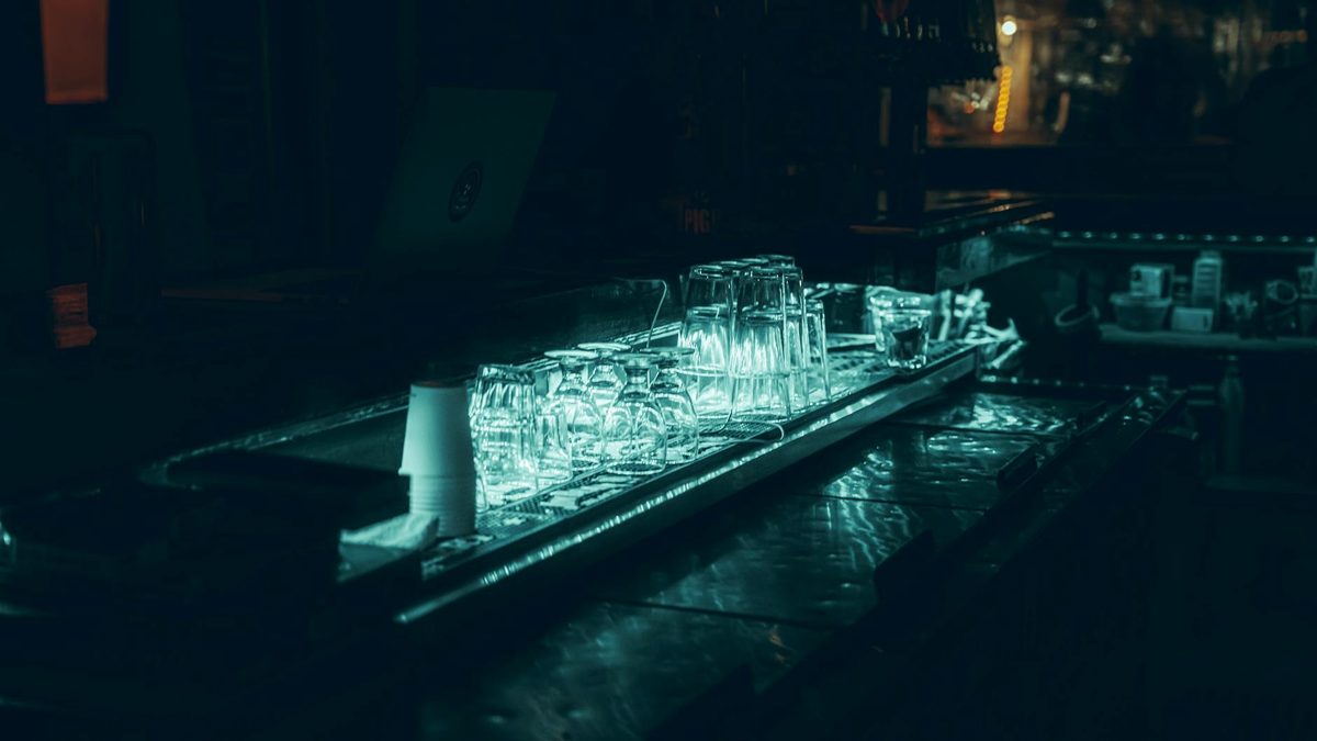 Dimly lit bar scene with glasses on the counter