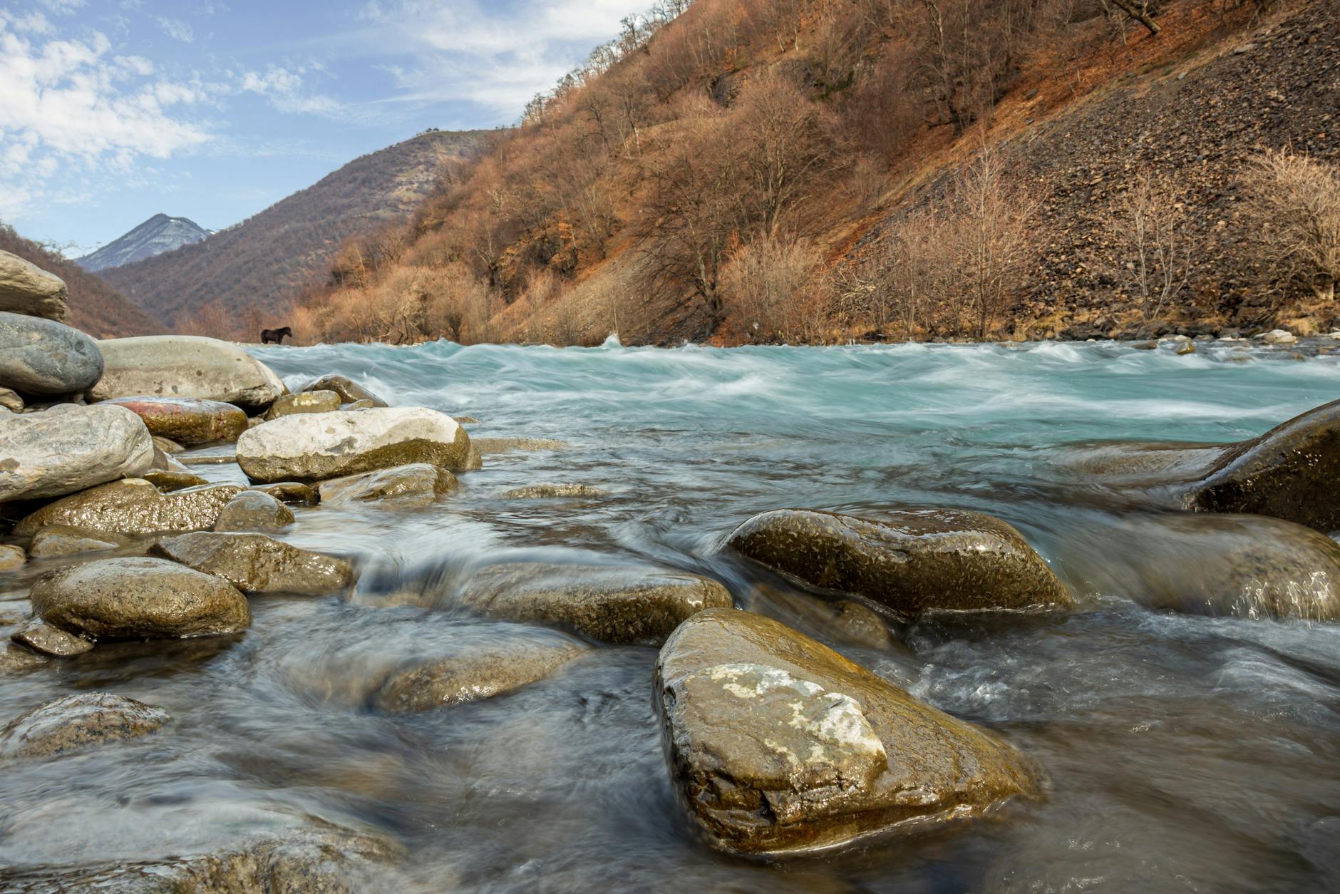 River flowing through mountain valley with rocky riverbed
