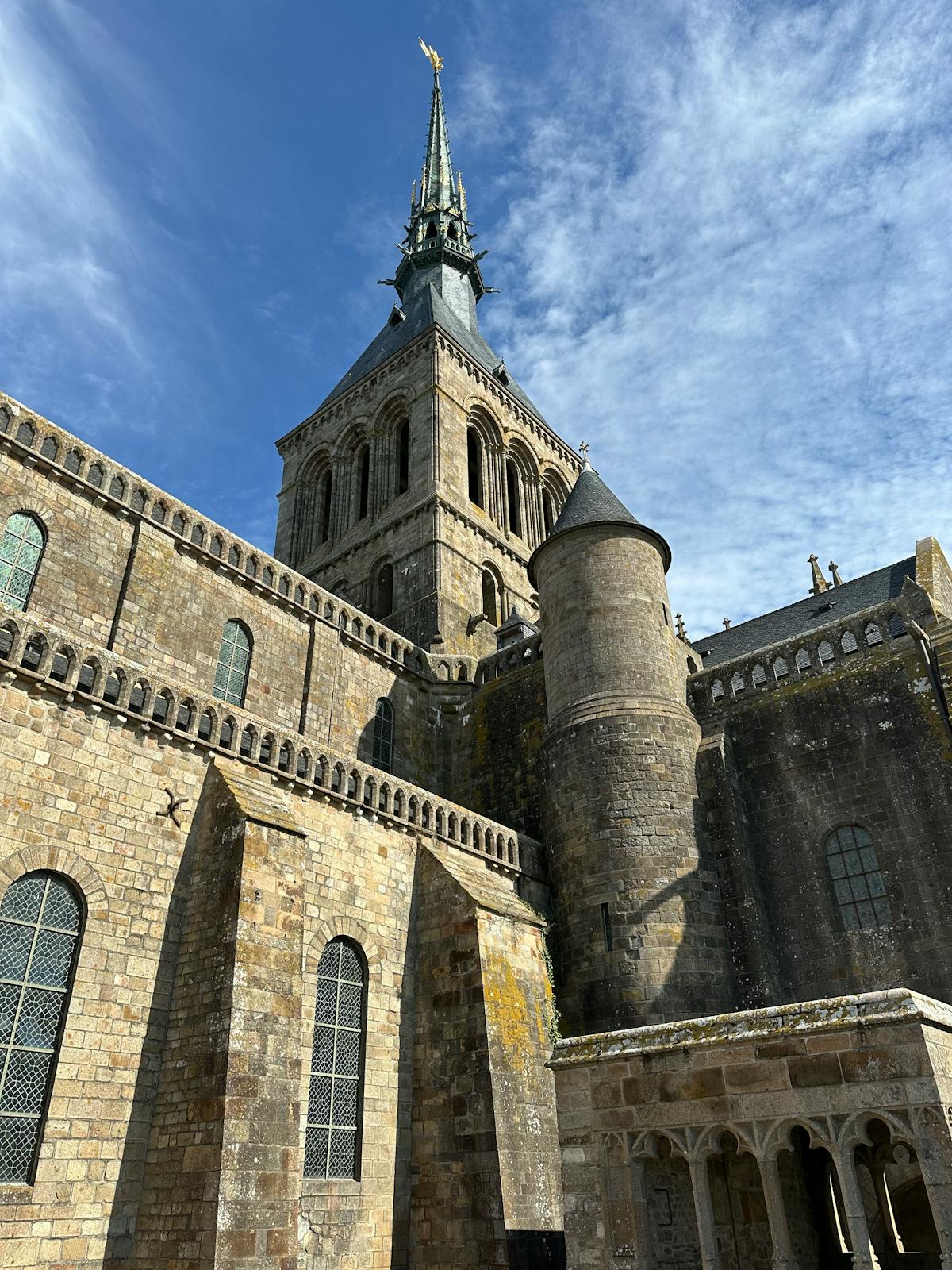Historic Mont-Saint-Michel Abbey architecture against a vibrant blue sky