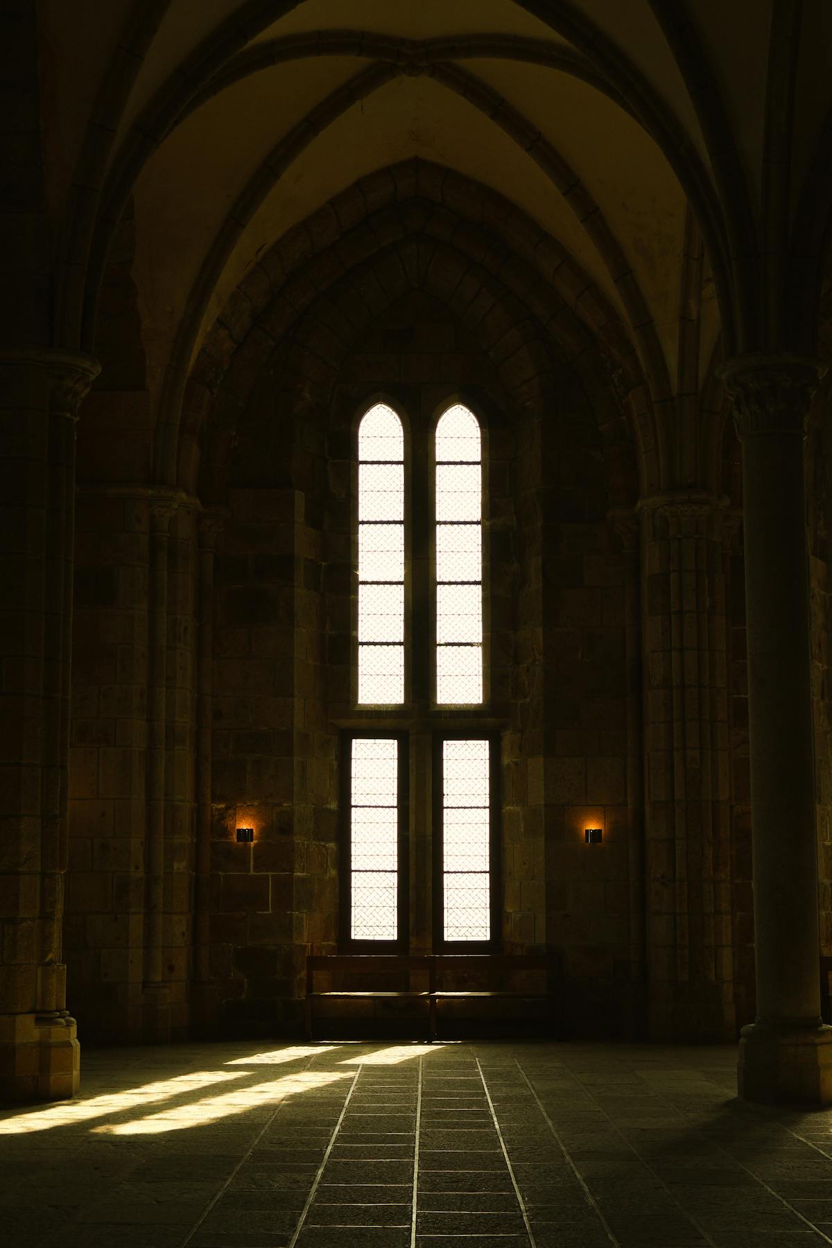 Dramatic lighting in the gothic interior of Mont-Saint-Michel Abbey with stone arches