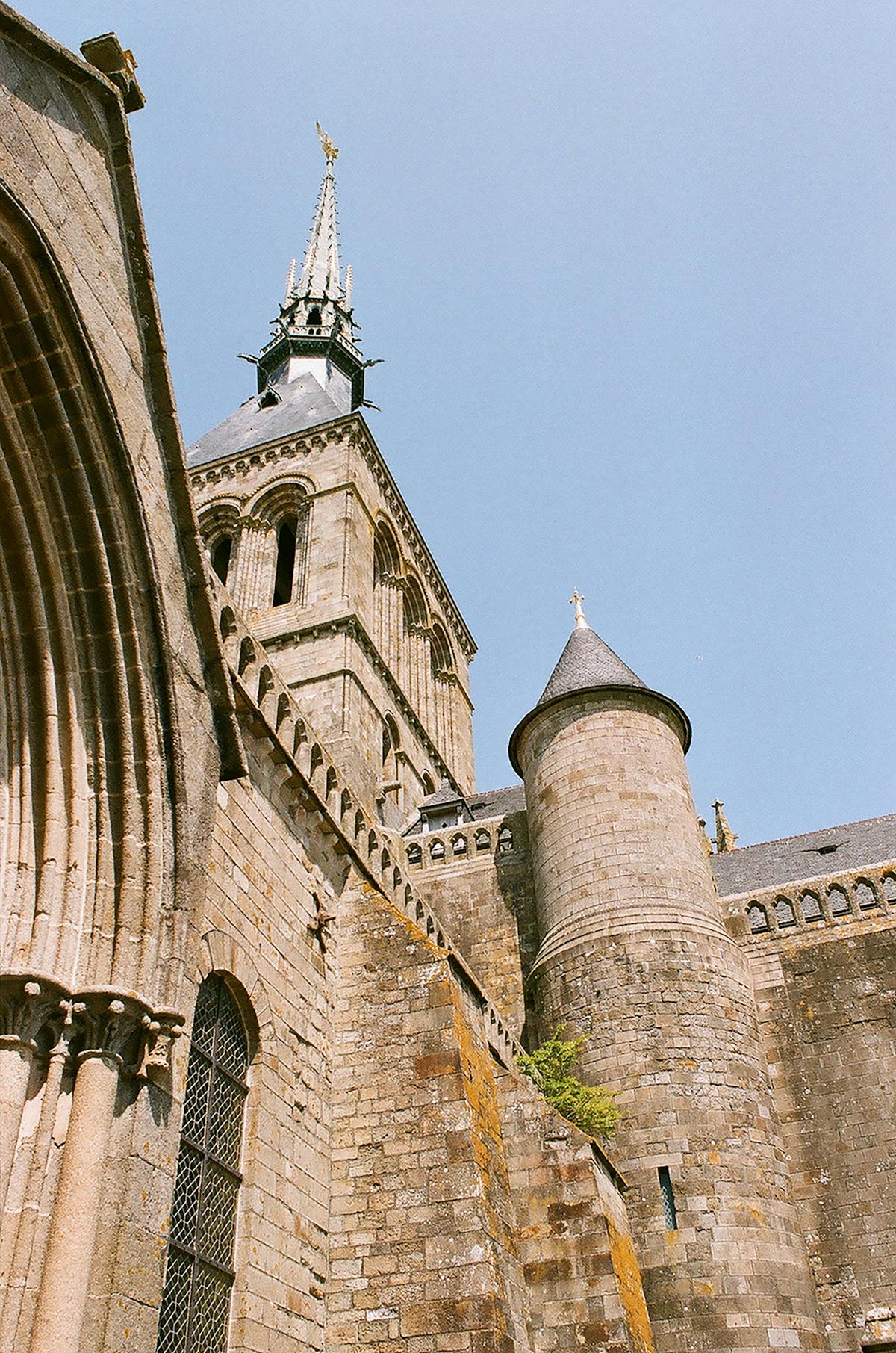 Explore the stunning architecture of Mont-Saint-Michel Abbey against a clear summer sky