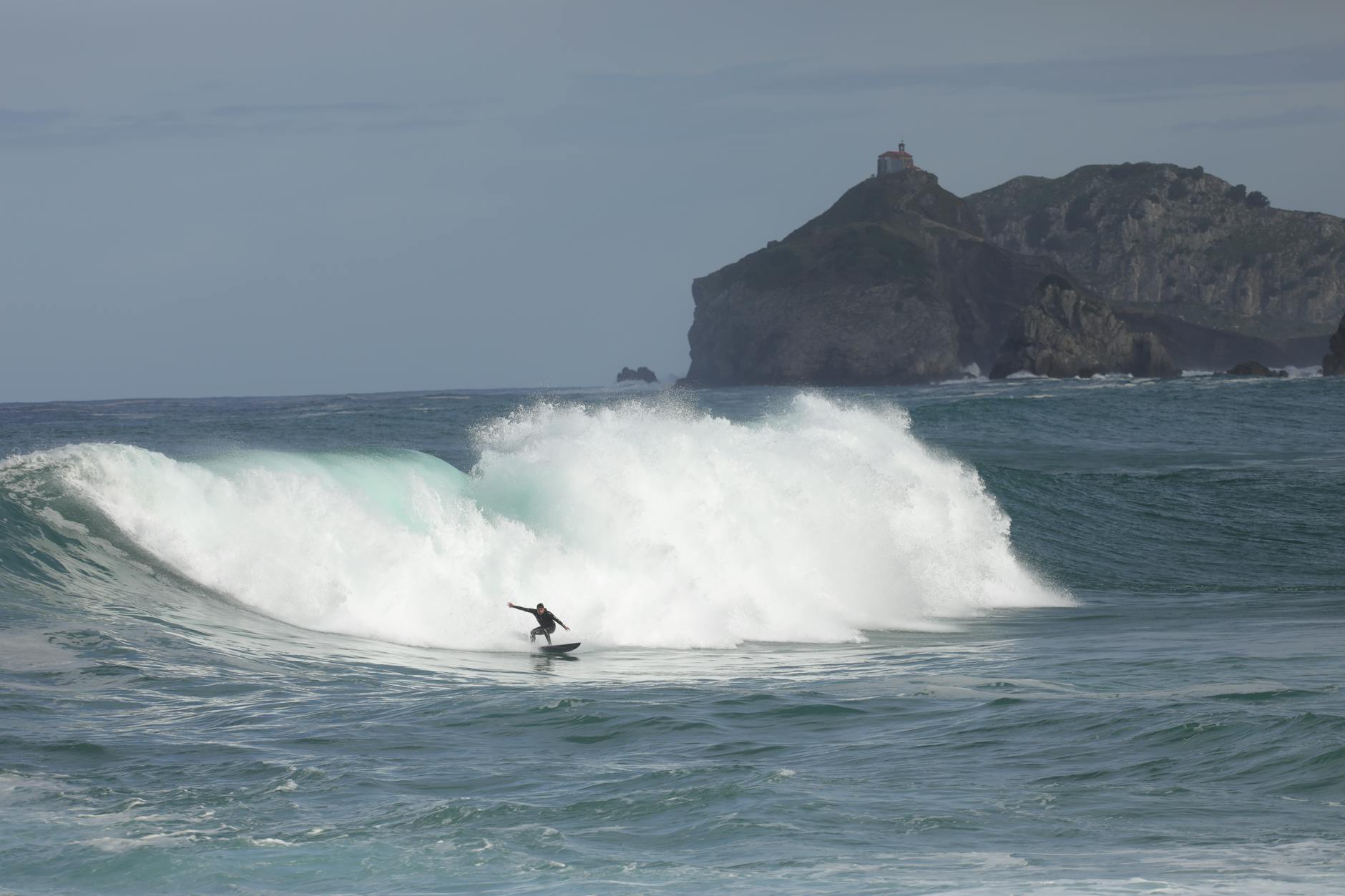 Surfer riding a wave at Mundaka beach in the Basque Country Spain