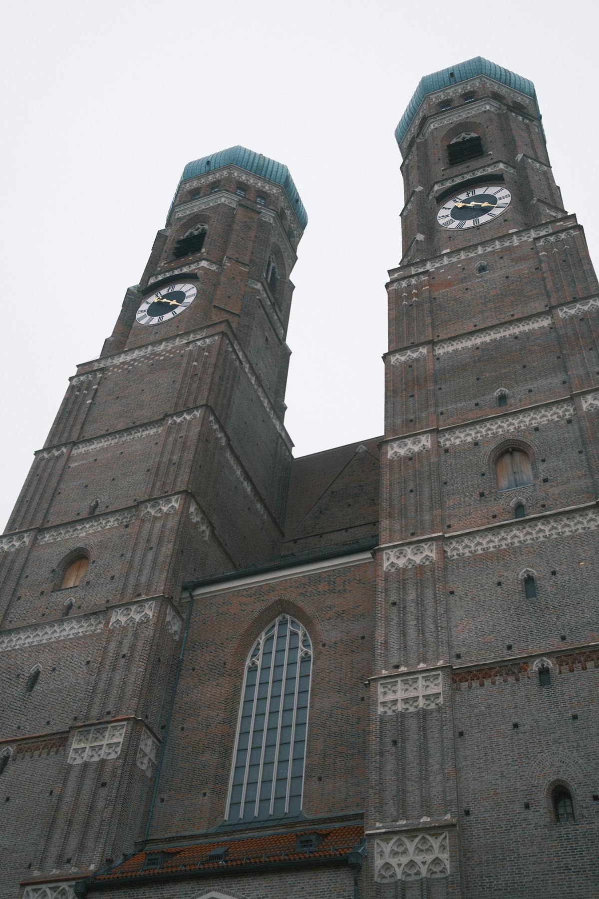 Close-up view of the Frauenkirche twin towers against a cloudy sky in Munich