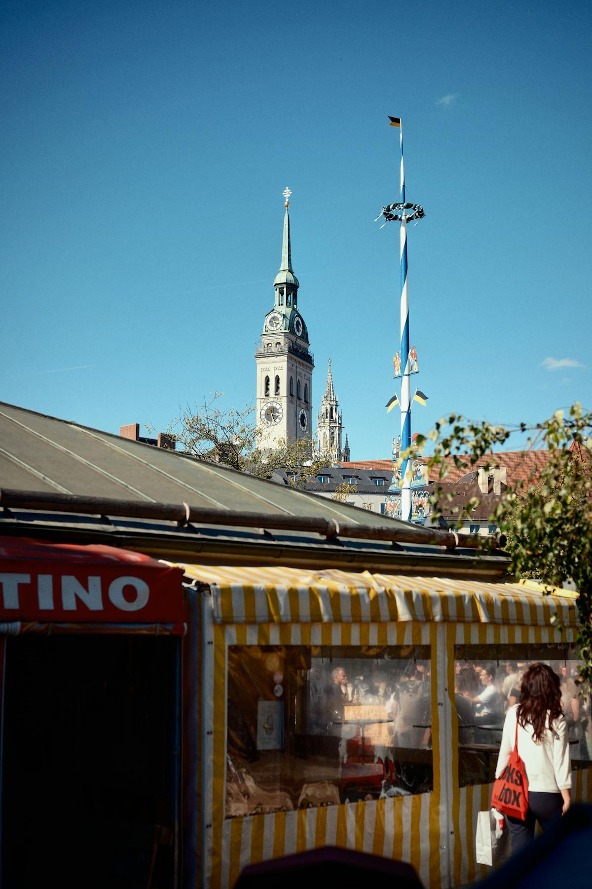 Munich street scene with iconic church tower and market stall
