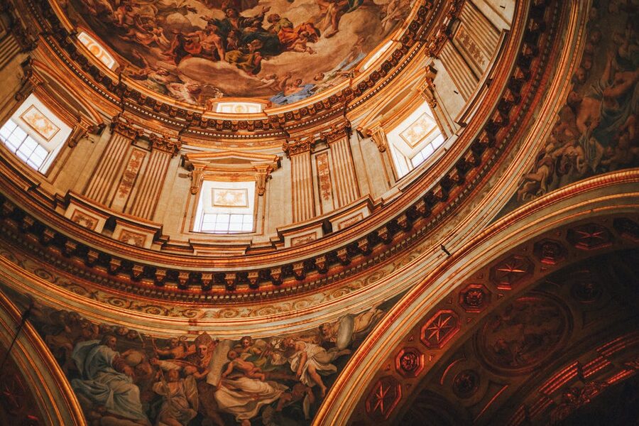 Stunning view of a Baroque church dome in Naples showing intricate ceiling frescoes and architectural details